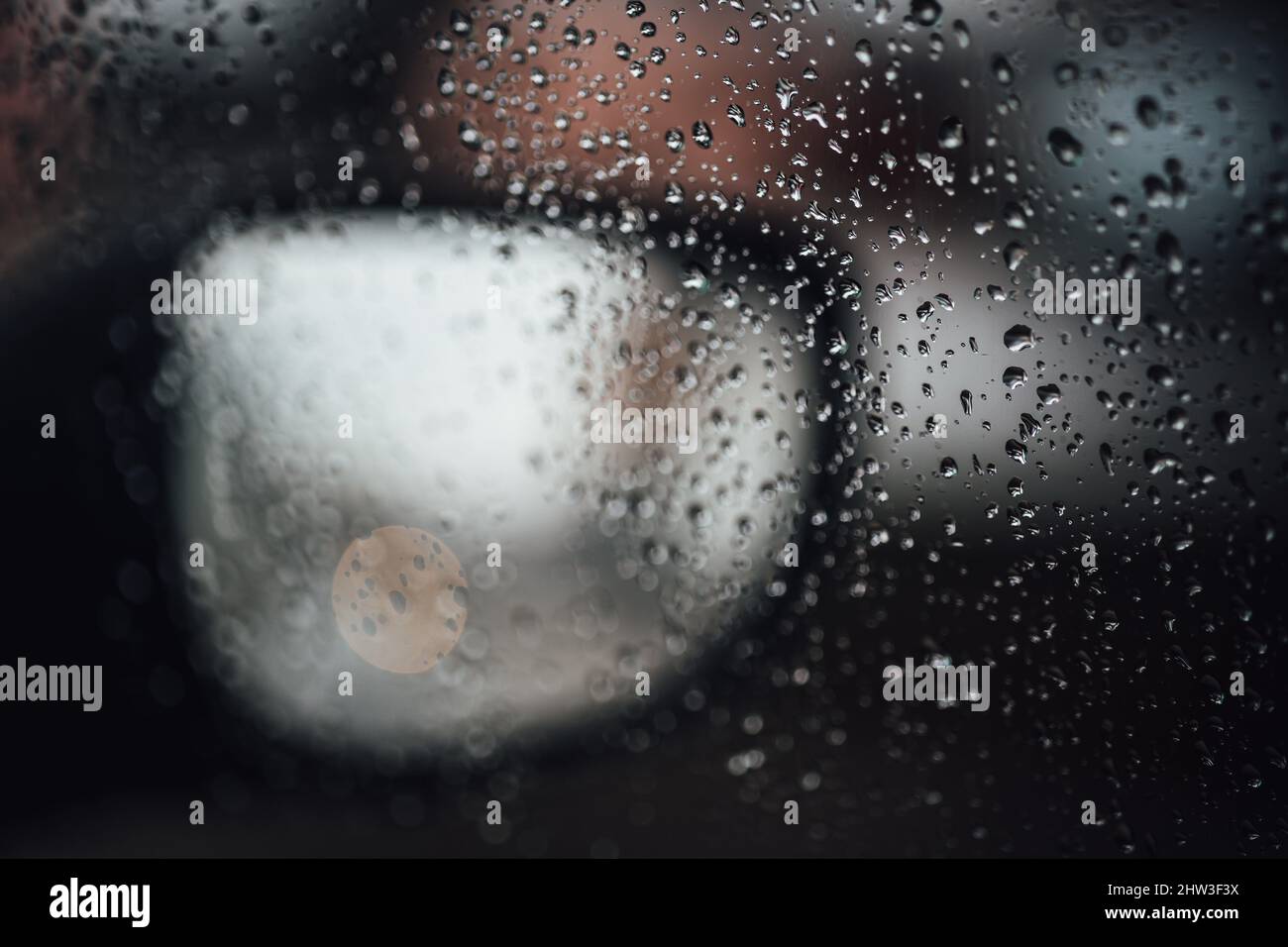 Wet car window with raindrops and a mirror behind Stock Photo - Alamy