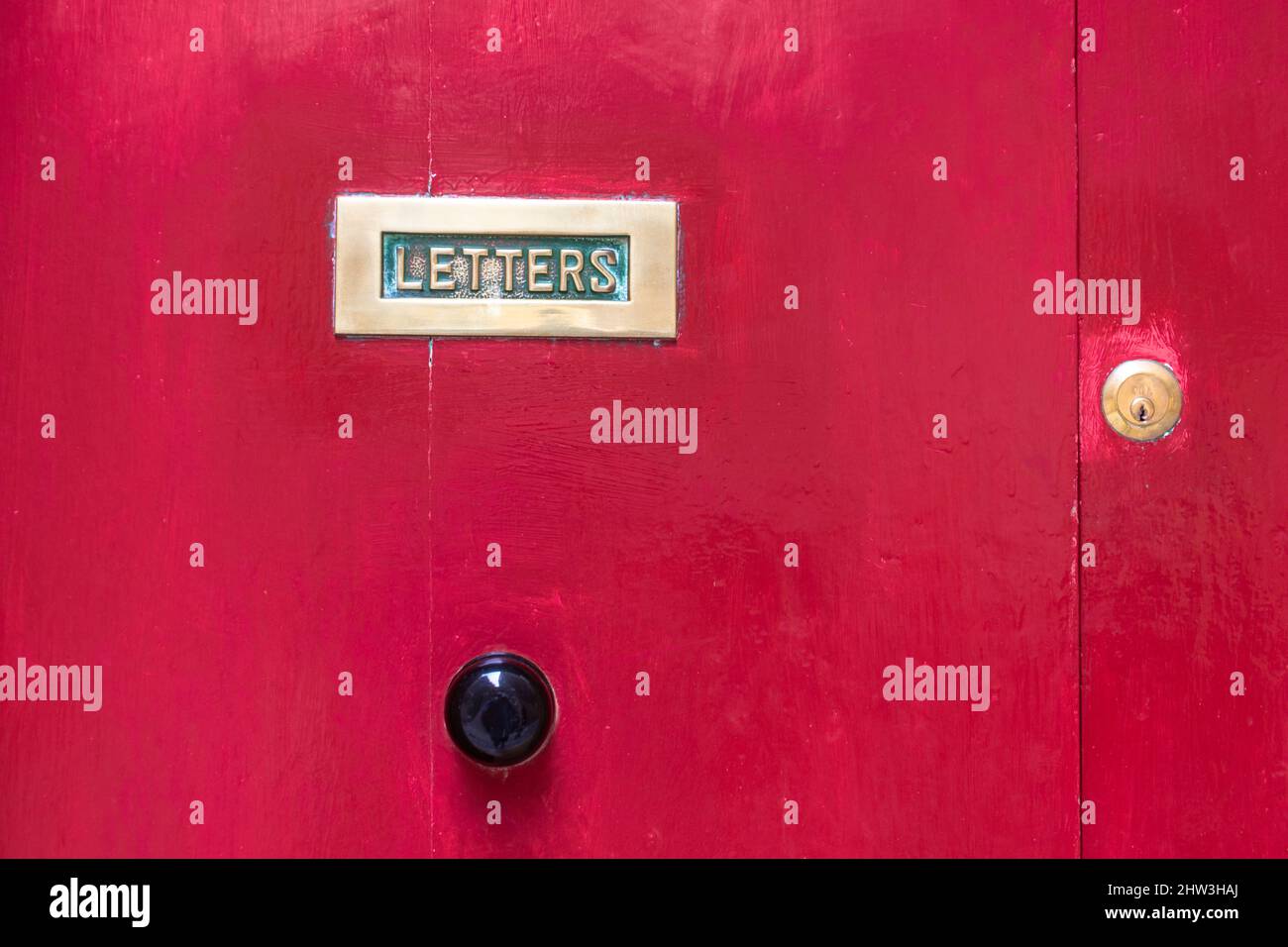 Letterbox with a red door door knob background Stock Photo - Alamy