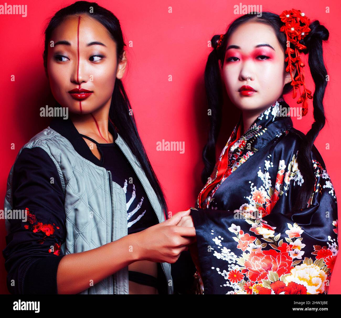 two pretty geisha friends: modern asian woman and traditional wearing ...