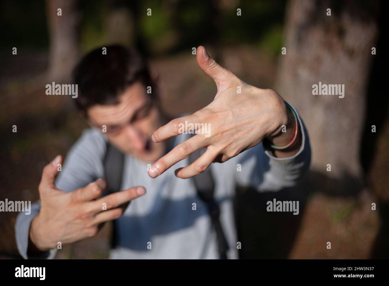 A young man shows gestures with his hands. The guy shows movements with ...