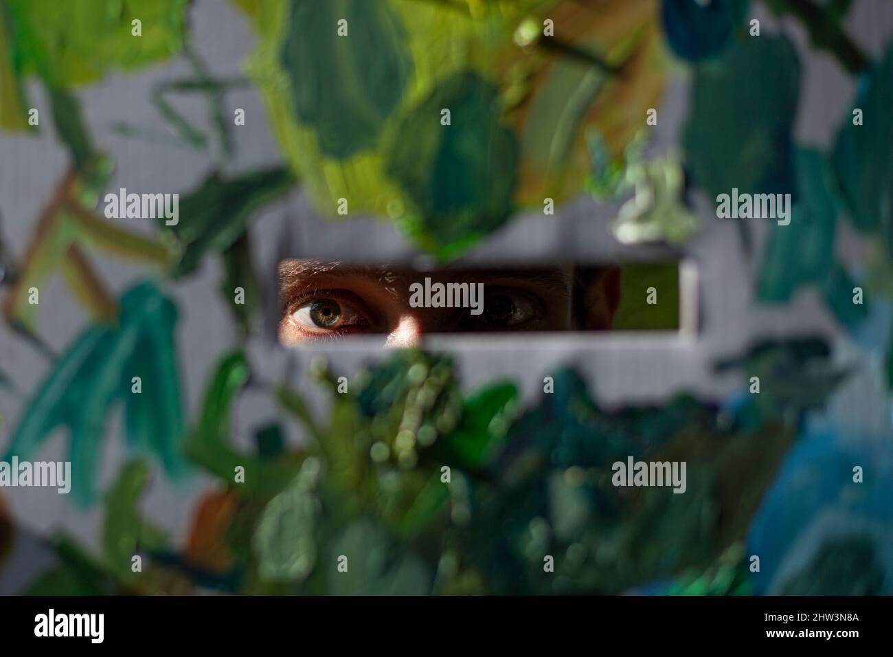 The guy is looking at you through a slot in the palette. Artist looks ...