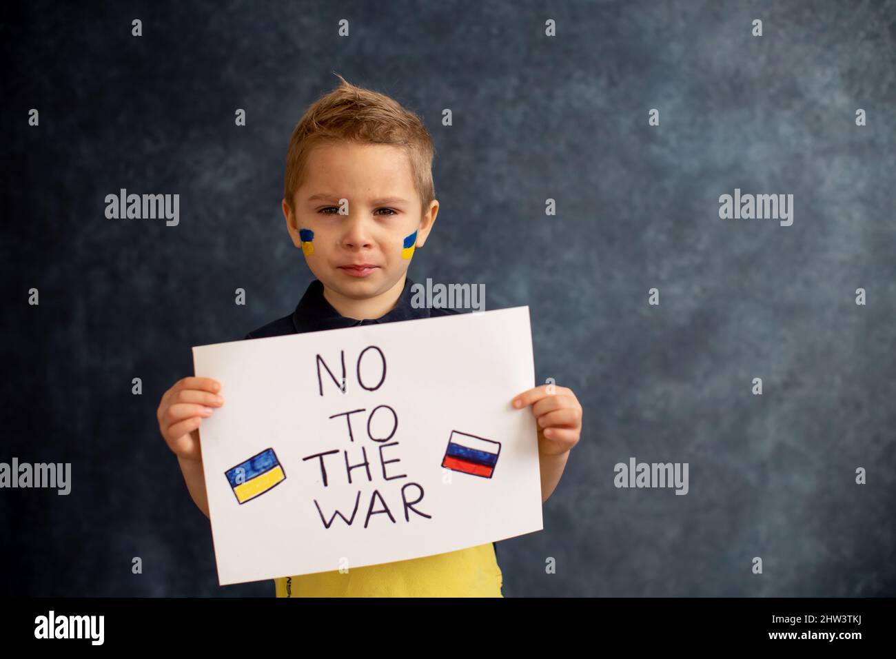 Young blond child, holding sign in support to peace, no war wanted, kid ...