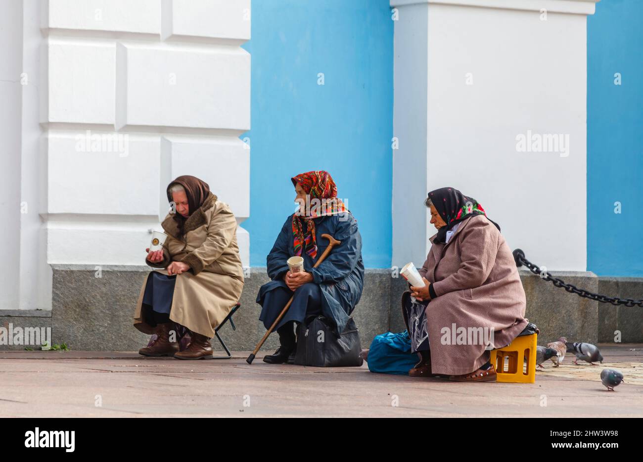Three local old poor women sit outside St Michael's Golden Domed ...