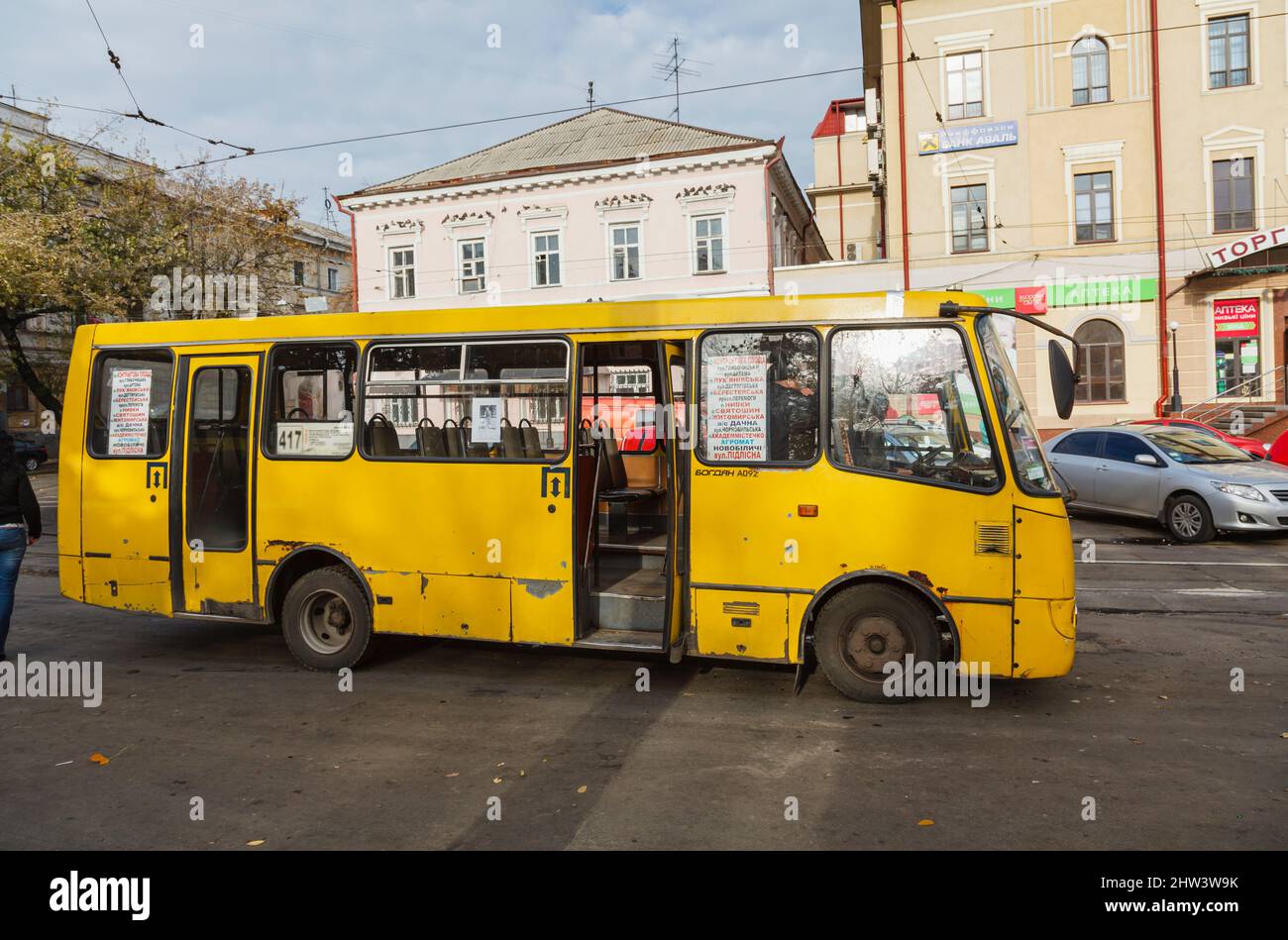 A typical battered single decker yellow bus with rust and peeling ...