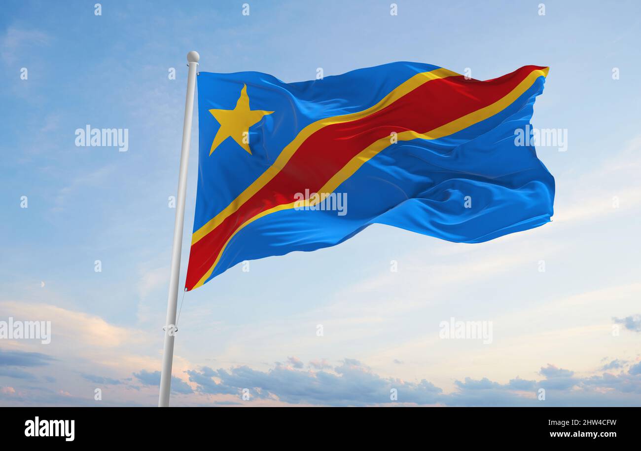 official flag of Congo Kinshasa at cloudy sky background on sunset ...