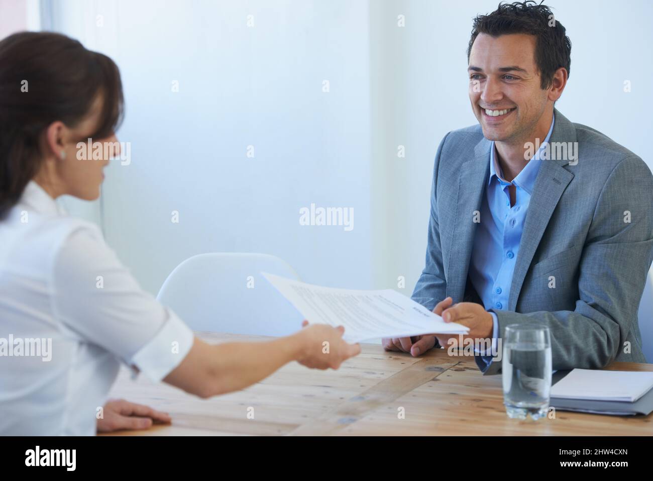 Handing him her resume. A pretty young woman handing her resume to a ...