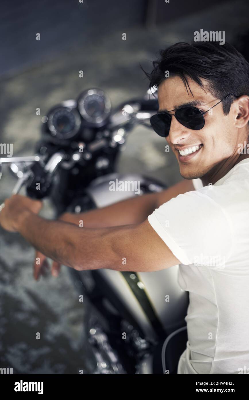Ready for the road. A handsome young man sitting on his motorcycle ...