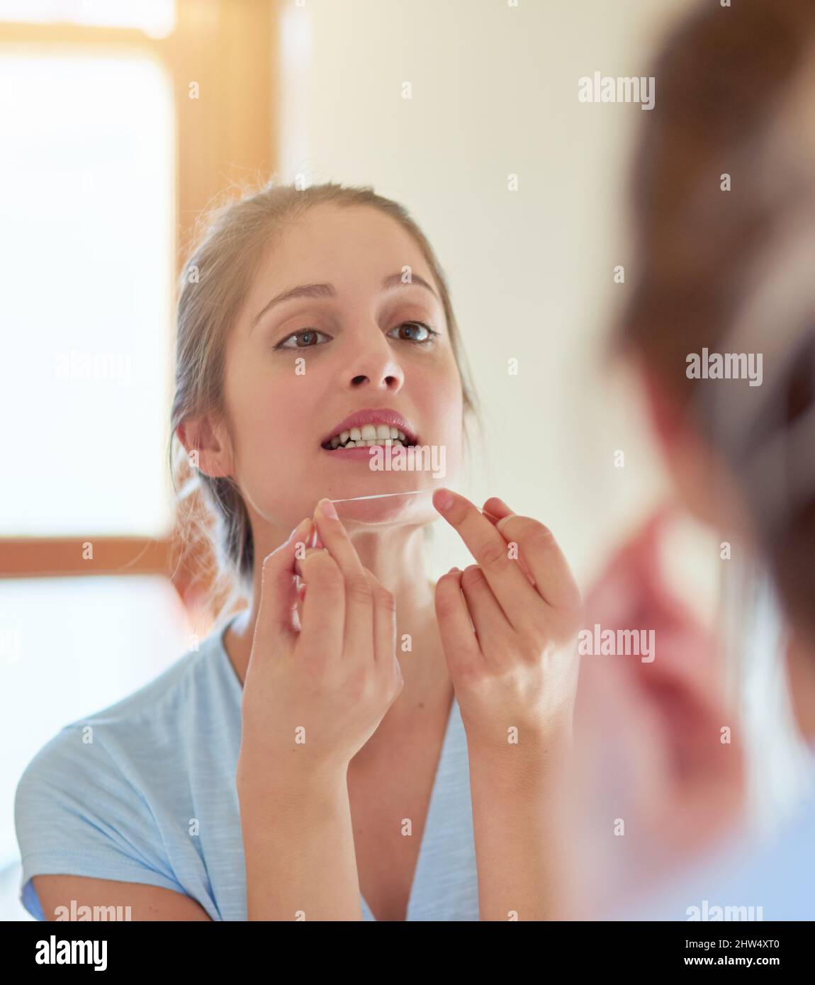 Flossing is part of her daily routine. Cropped shot of a young woman ...
