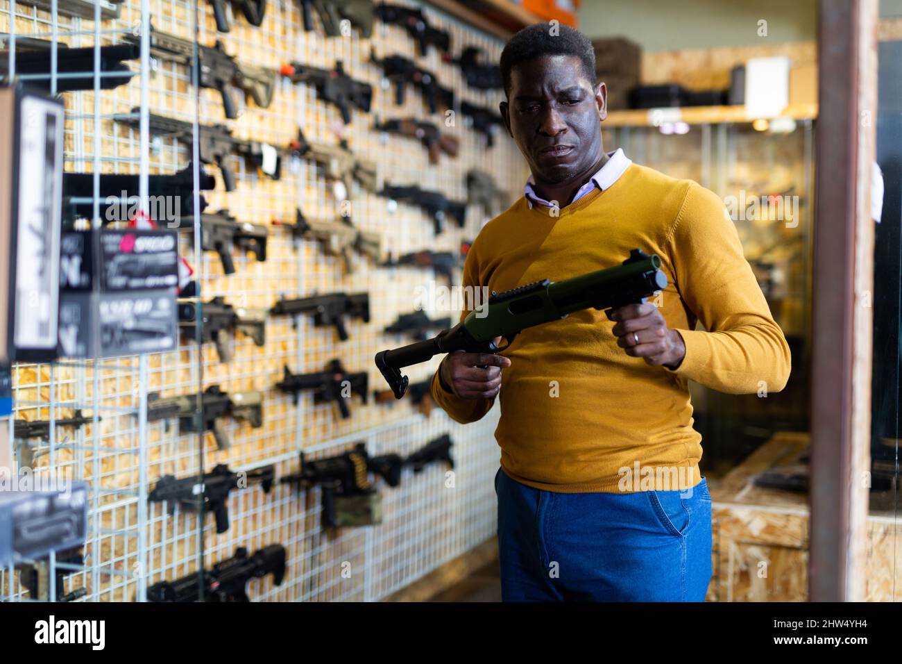 Man with shotgun in airsoft shop Stock Photo - Alamy