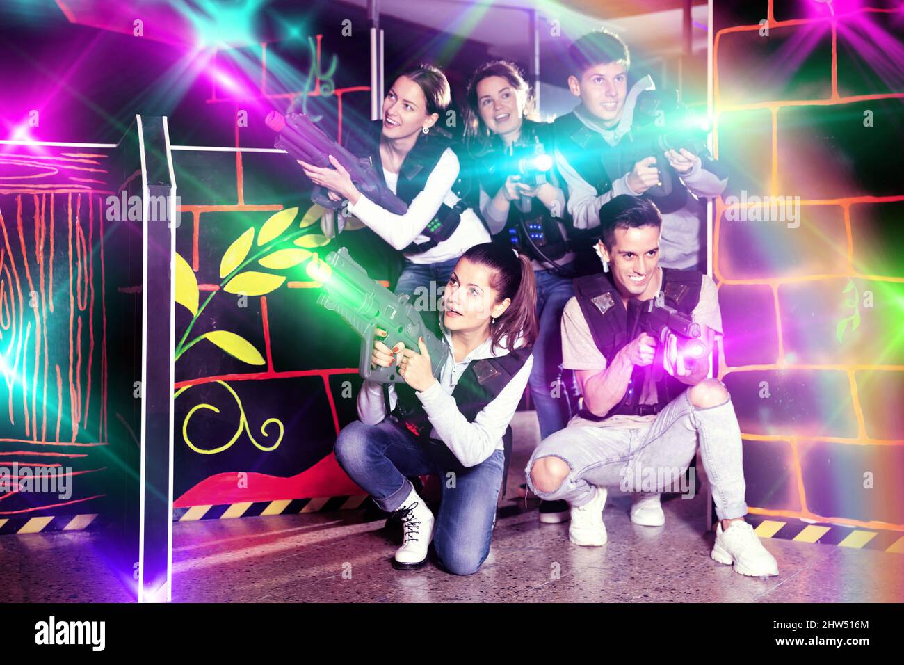 Group glad people playing laser tag game Stock Photo - Alamy