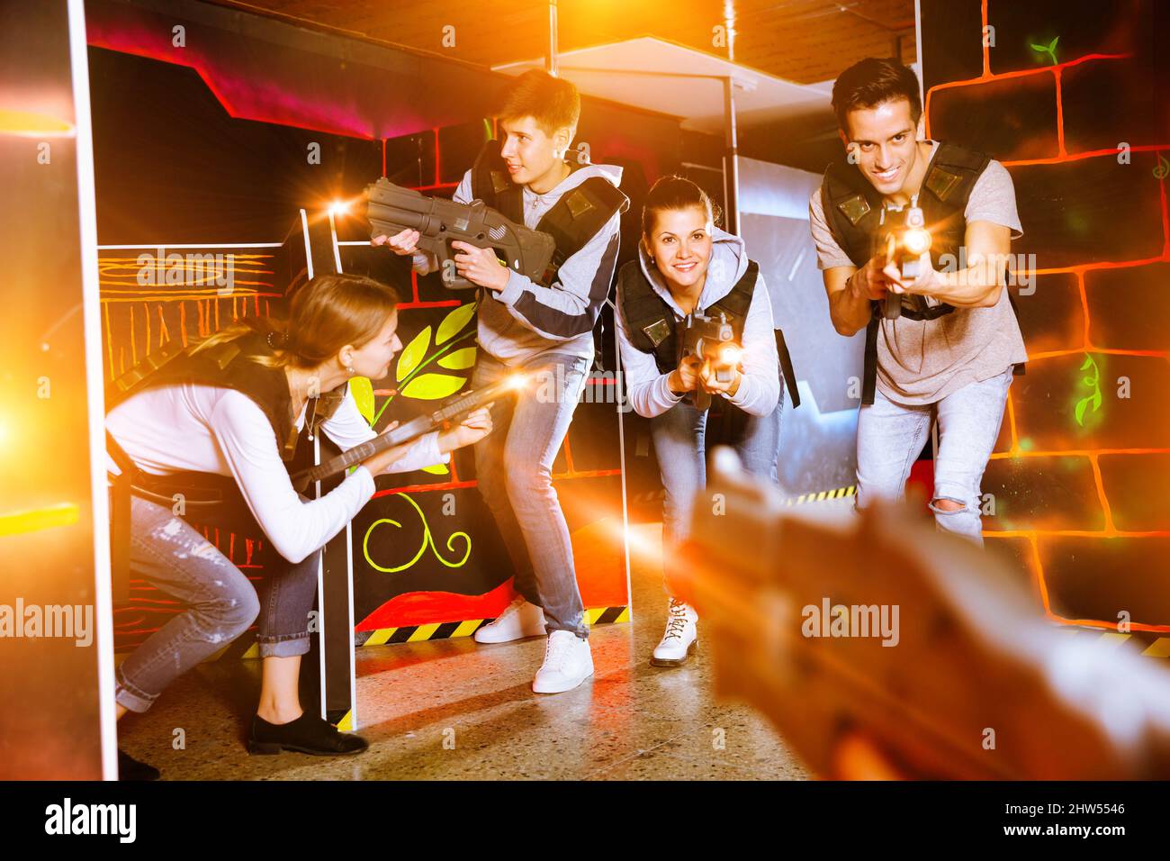 Group of young people playing laser tag game with laser guns Stock ...
