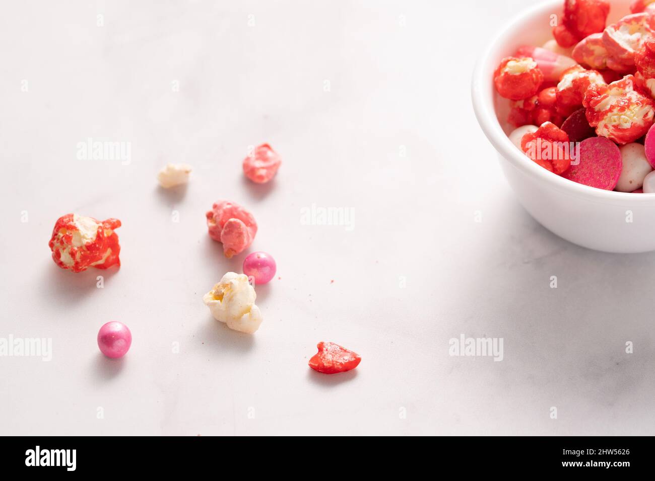 Colorful red and pink candied popcorn with mixed candies in bowl Stock ...