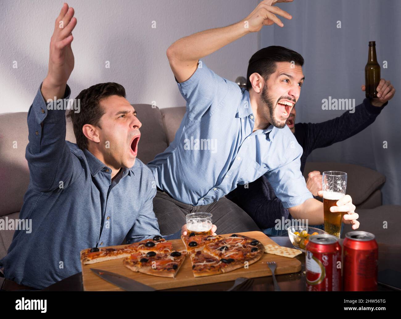 Males watching tv at home and having fun Stock Photo - Alamy