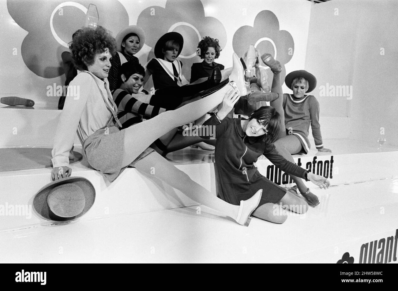 Mary Quant Pictured In Black Sitting Down At The Front Holding The Shoe Of A Model At The Mary