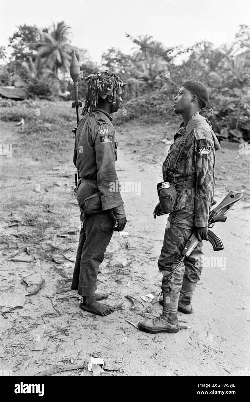 Two heavily armed Biafran soldiers seen here talking to each other ...