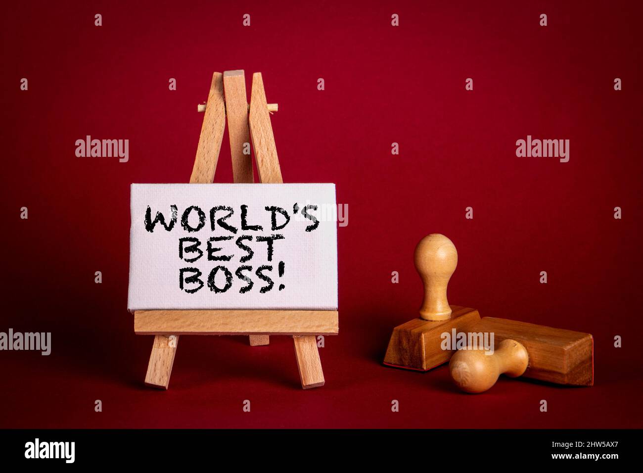 World's Best Boss. Miniature easel with text and wooden stamps on a red ...