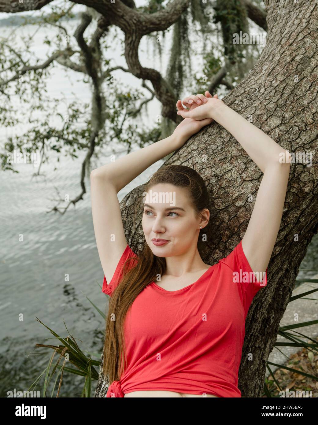 Woman sitting against tree trunk hi-res stock photography and images ...