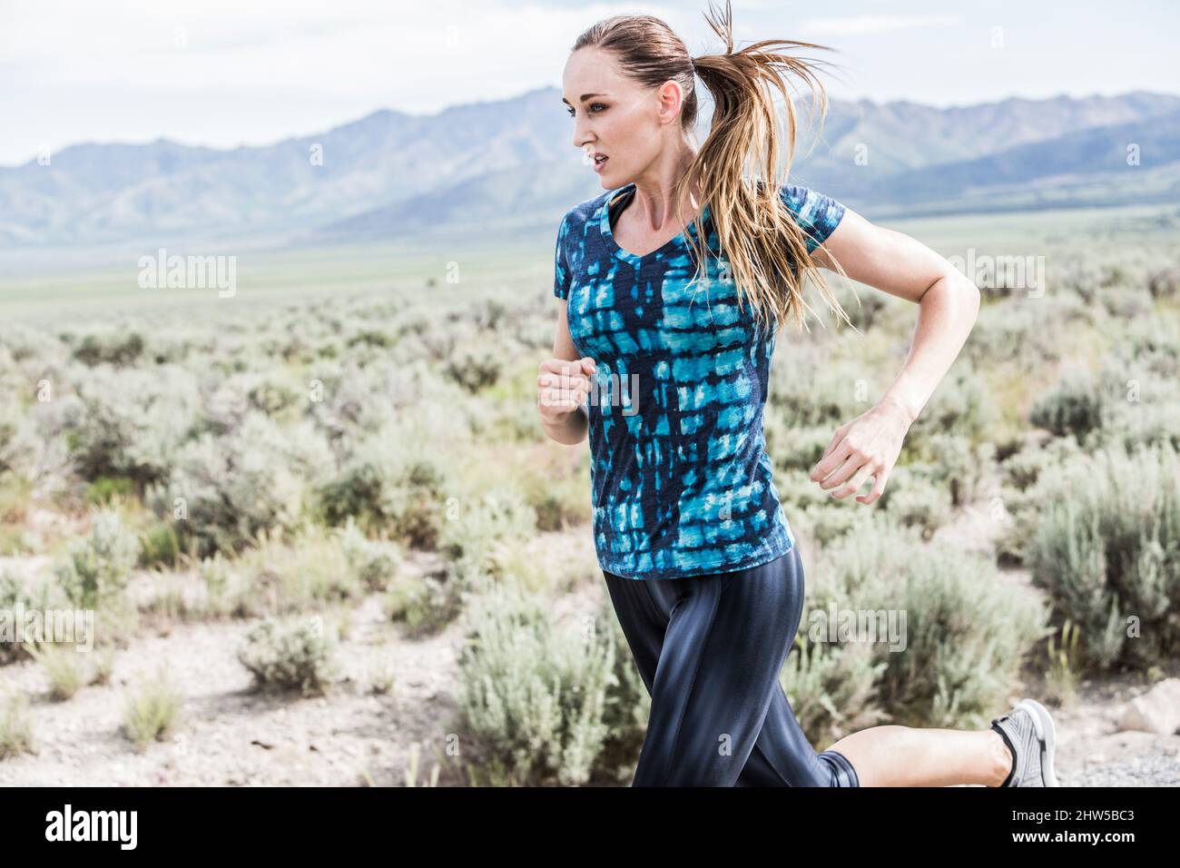 United States, Utah, Cedar Fort, Woman jogging in desert landscape ...