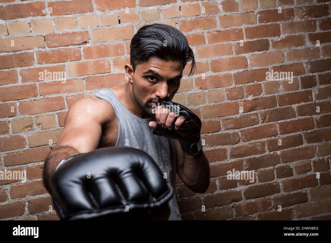 Portrait of man with boxing gloves against brick wall Stock Photo - Alamy