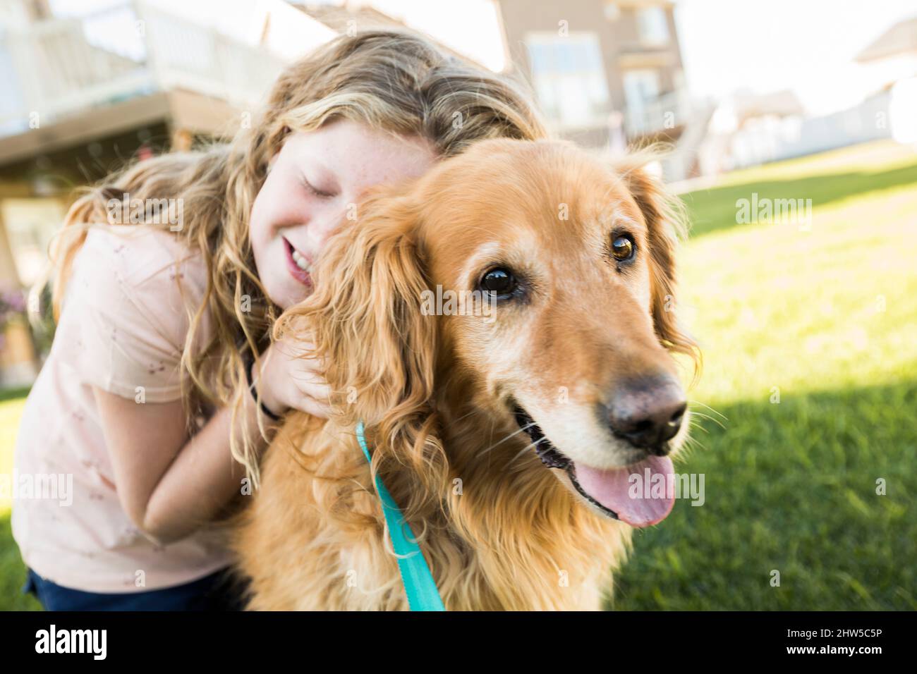 Girl (10-11) hugging Golden Retriever outdoors Stock Photo - Alamy
