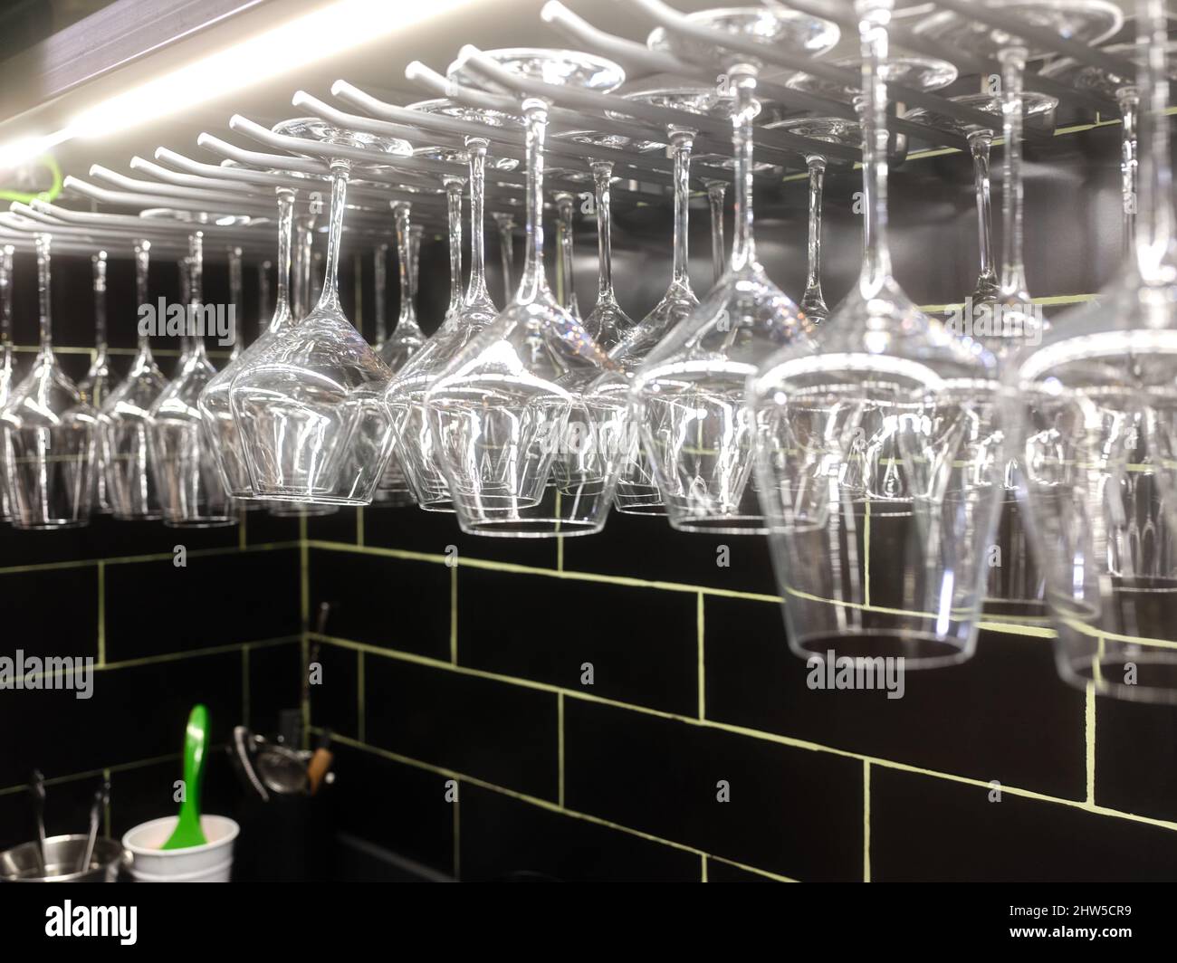 Wine glasses hanging from a rack in a restaurant Stock Photo - Alamy