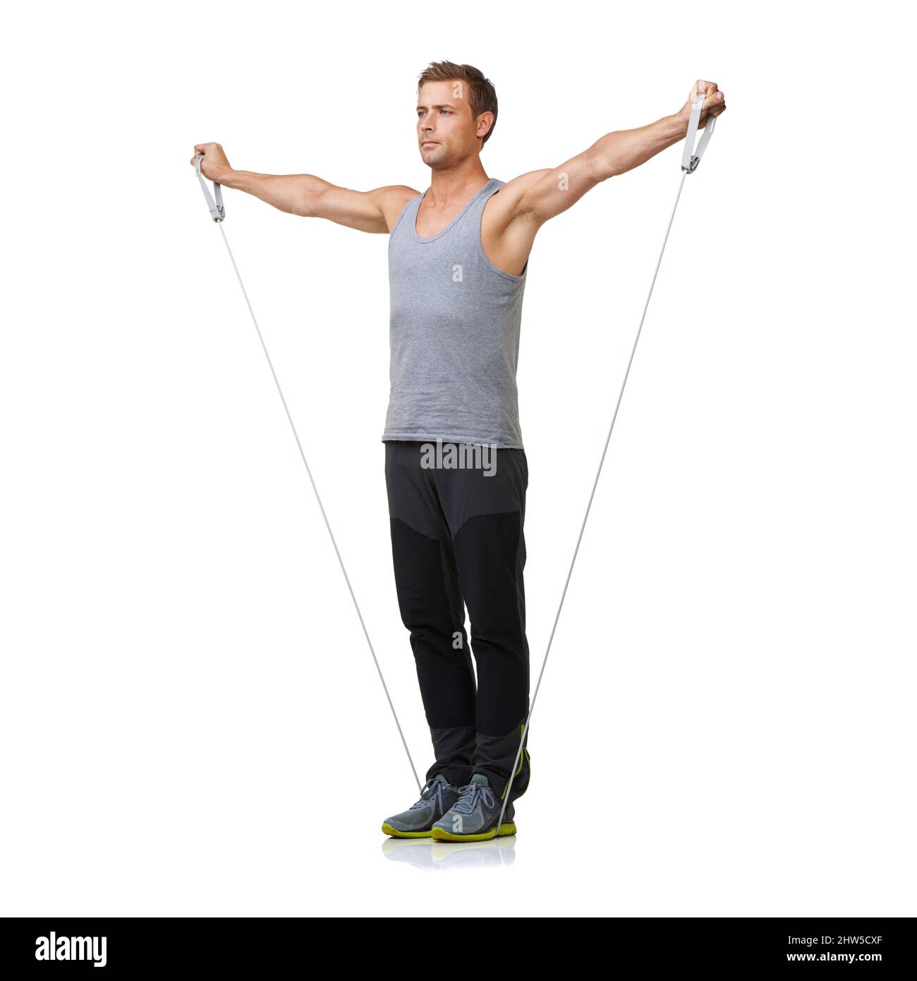 Extending his arms. A fit young man working out with a resistance band ...