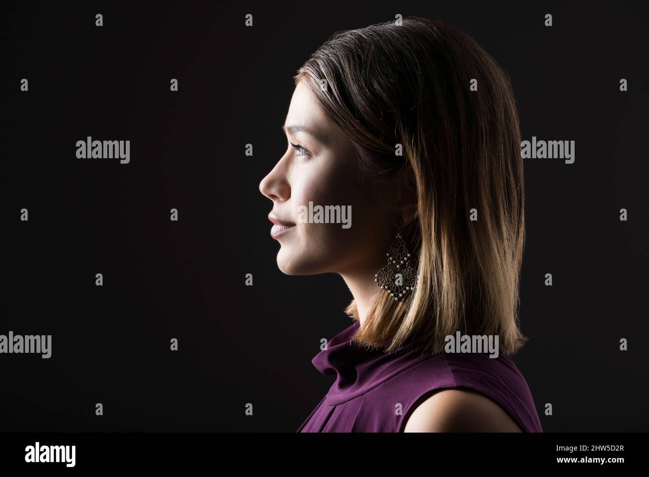 Profile of woman against black background Stock Photo - Alamy