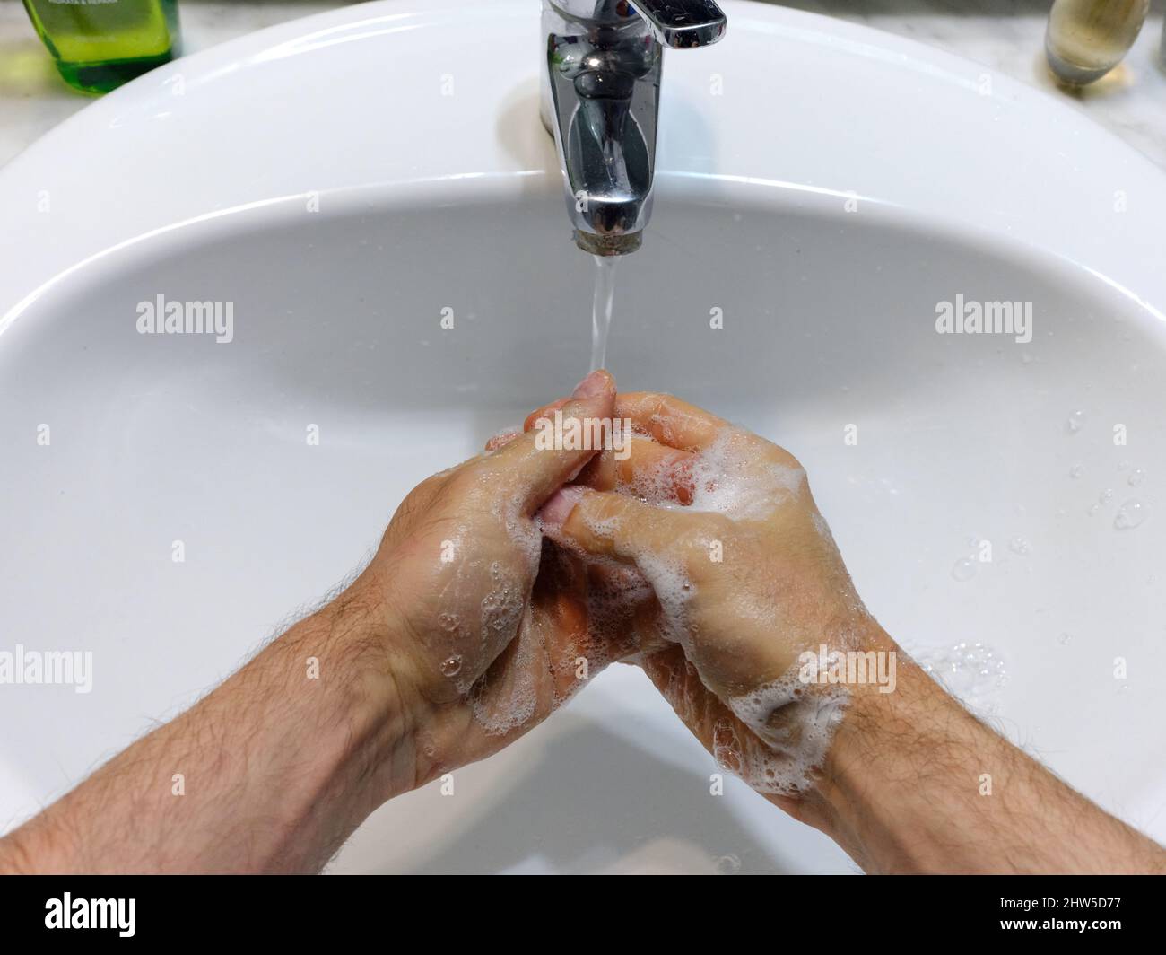 Person washing hands with soap on a bathroom Stock Photo - Alamy