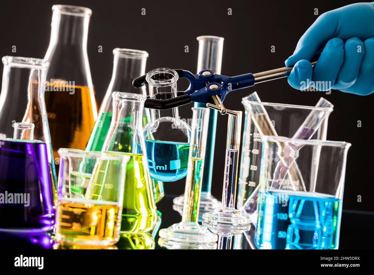 Chemist combining colorful liquids in laboratory glassware Stock Photo ...