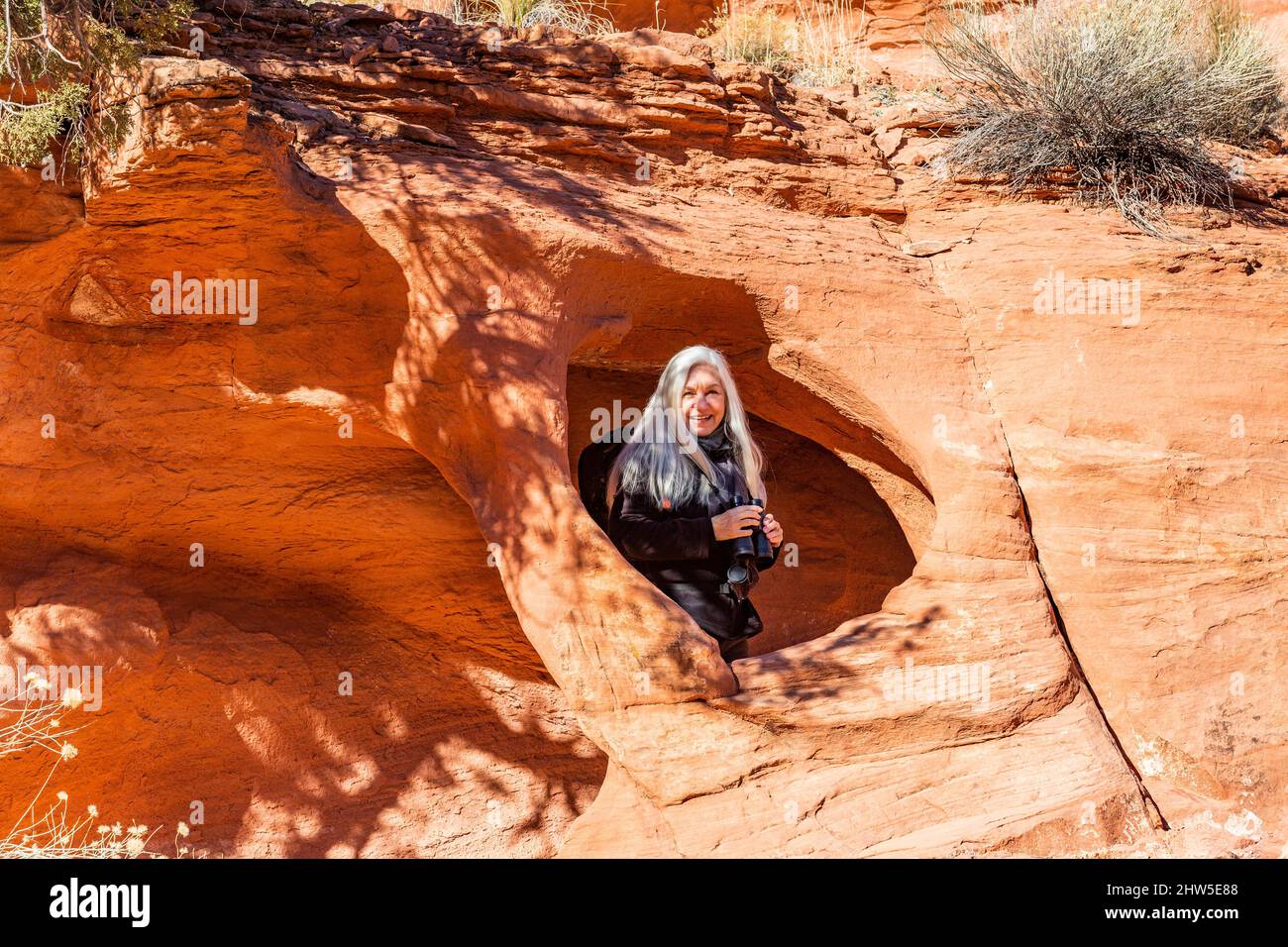 United States, Utah, Escalante, Senior hiker standing in rock opening ...