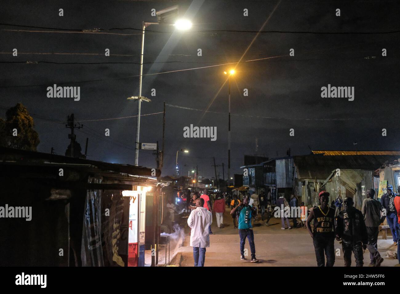 Local residents walk back home past the community solar powered street ...