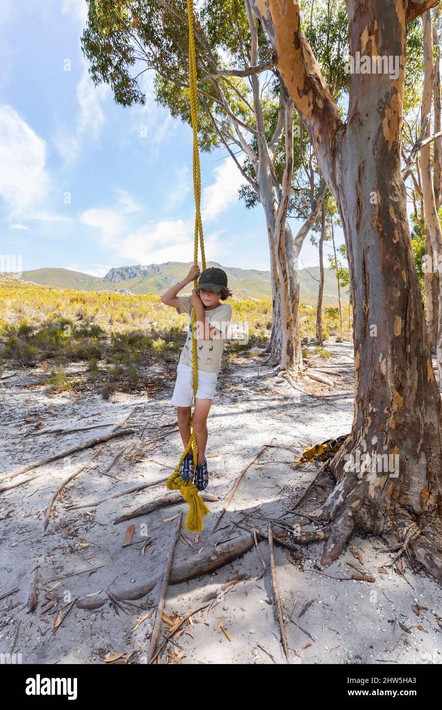 South Africa, Stanford, Boy (8-9) playing on tree rope inÂ PhillipskopÂ ...