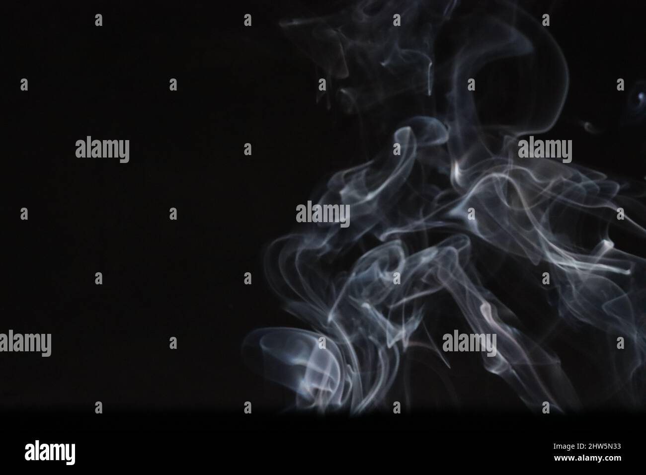 Closeup shot of the beautiful moving smoke on the black background ...
