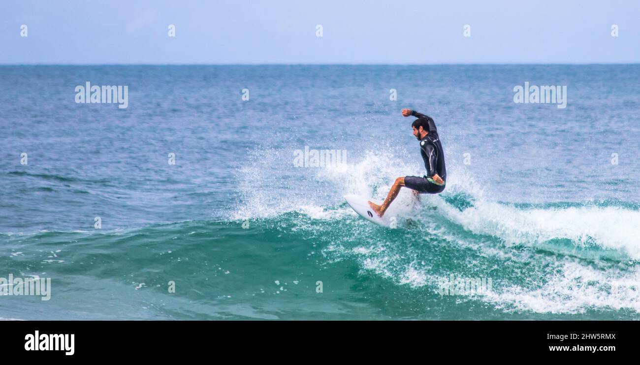 Surfer on blue ocean wave getting barreled at daytime Stock Photo - Alamy