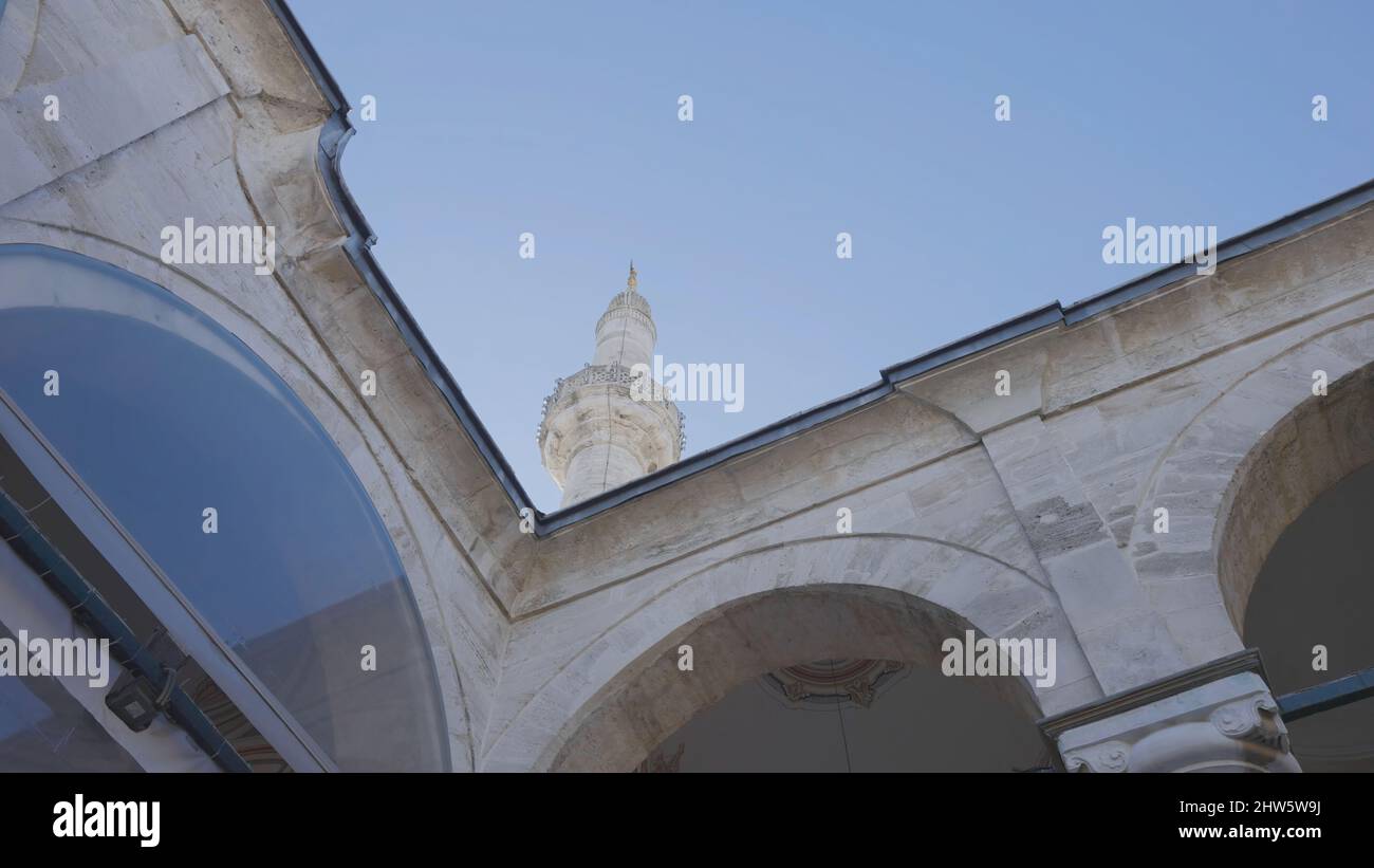 Tower and arches of mosque on background of blue sky. Action. Bottom ...