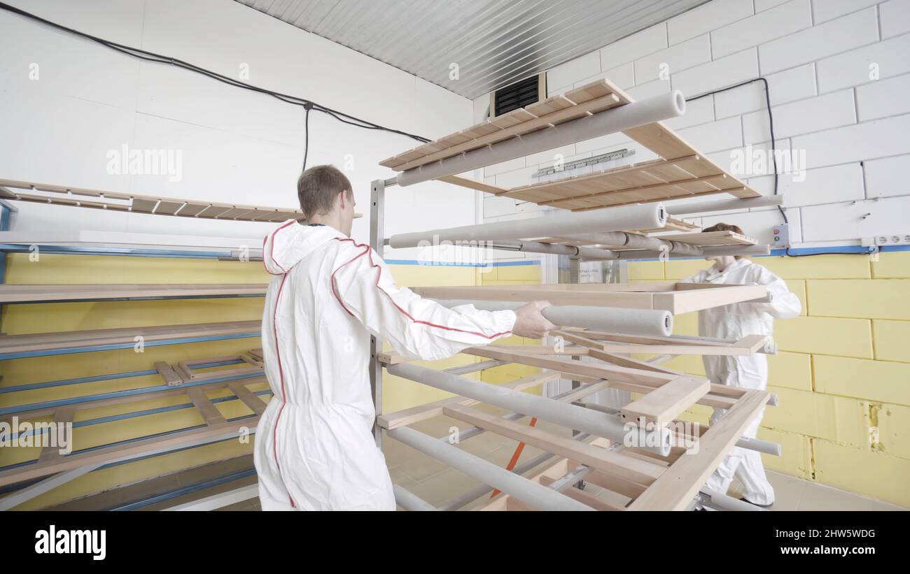 Workers transport wood frame at warehouse. Action. Two workers deliver ...