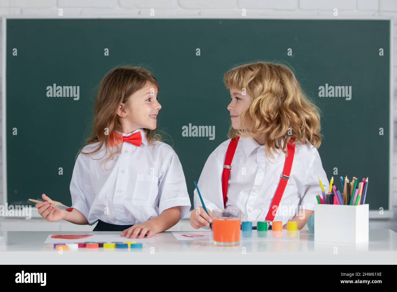 School children drawing a colorful pictures with pencil crayons in ...