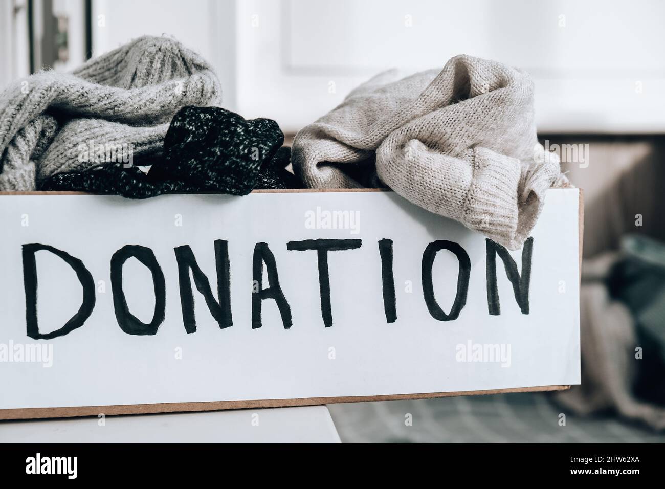 Donation box with old used clothes indoors. Happy Charity. Winter ...