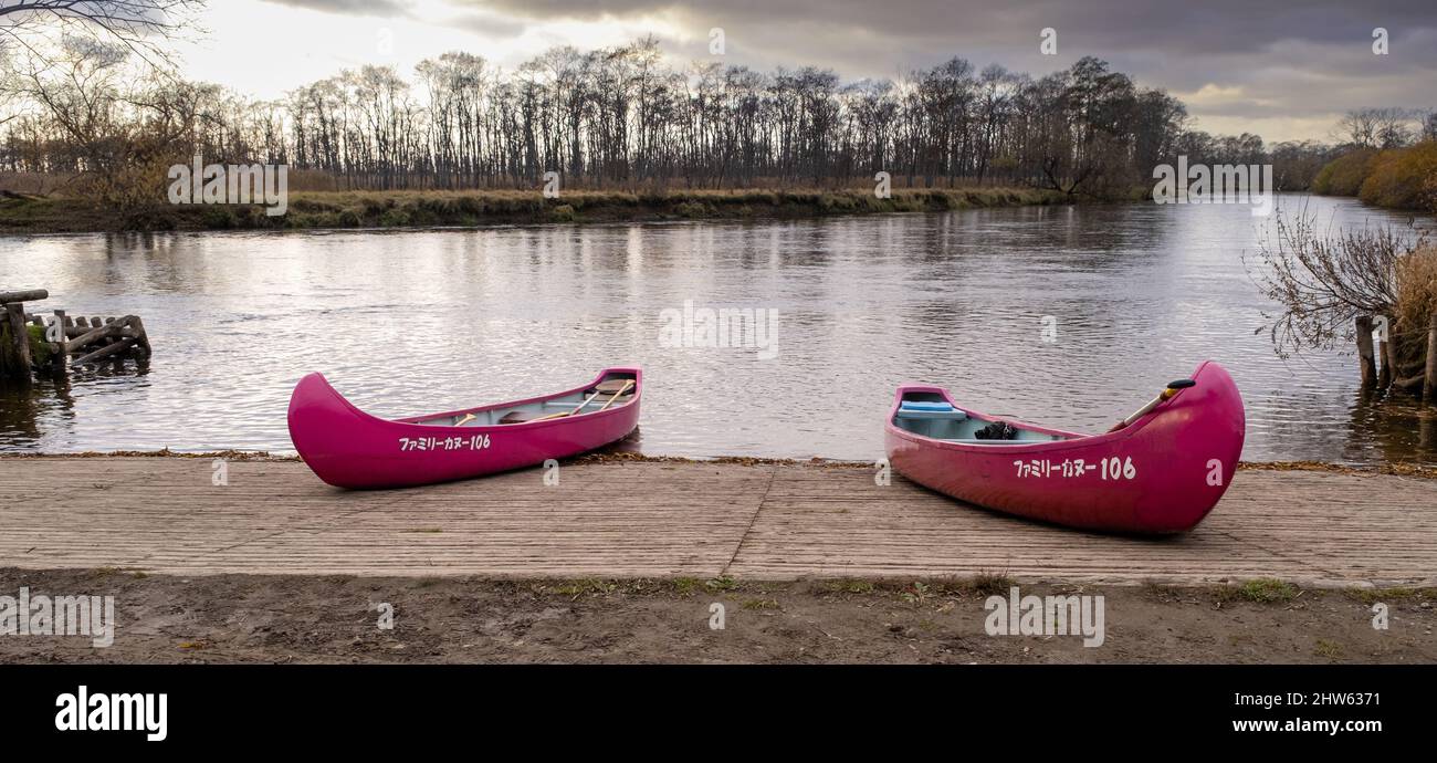 Red and white seven-person rental canoes on the boat ramp along the ...