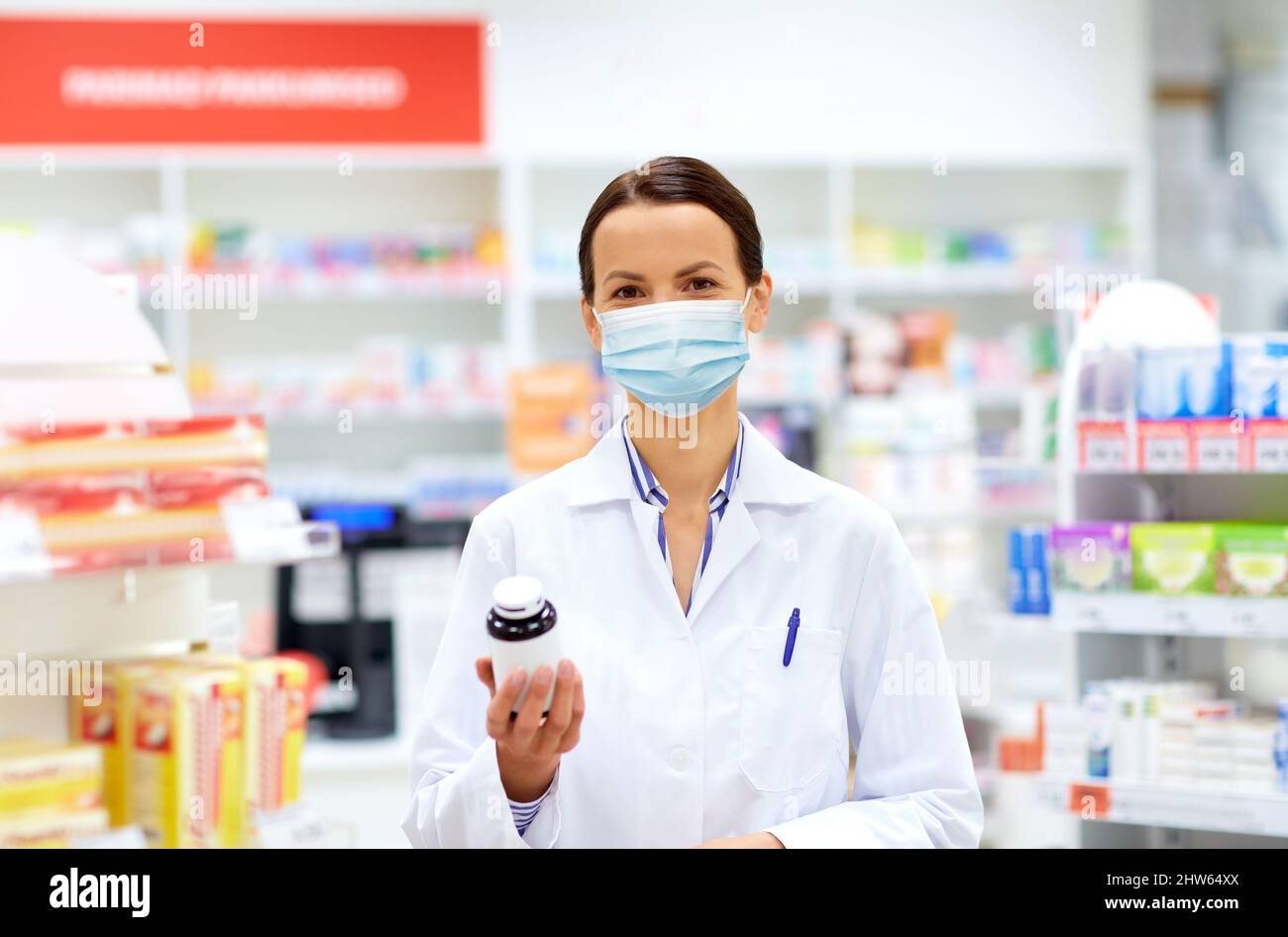 female apothecary in mask with drug at pharmacy Stock Photo - Alamy