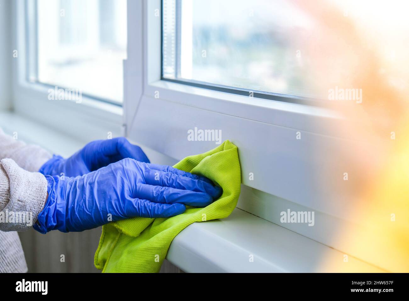 Cleaning the windowsill wiping dust by blue microfiber cloth for ...