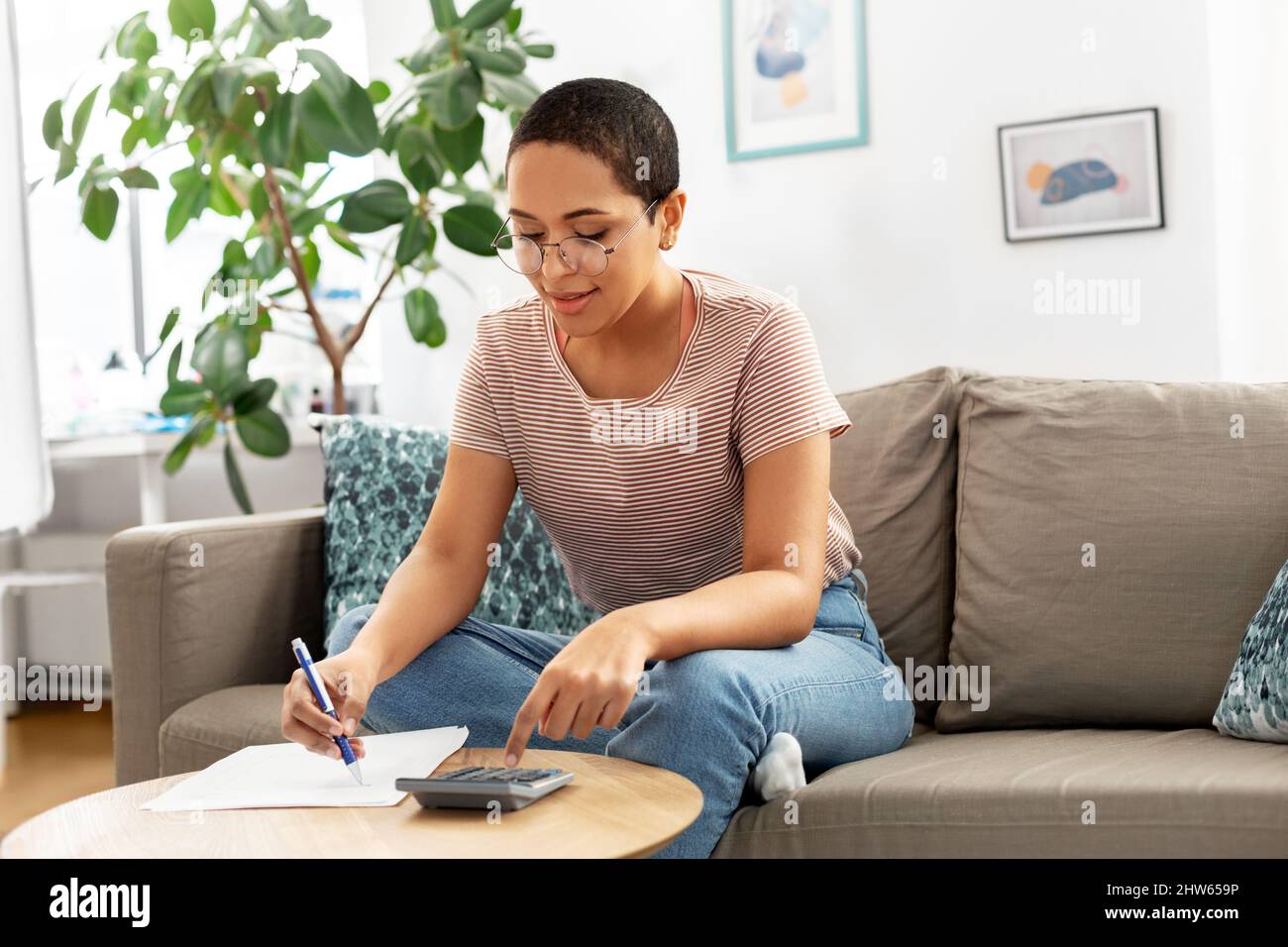 african woman with papers and calculator at home Stock Photo - Alamy
