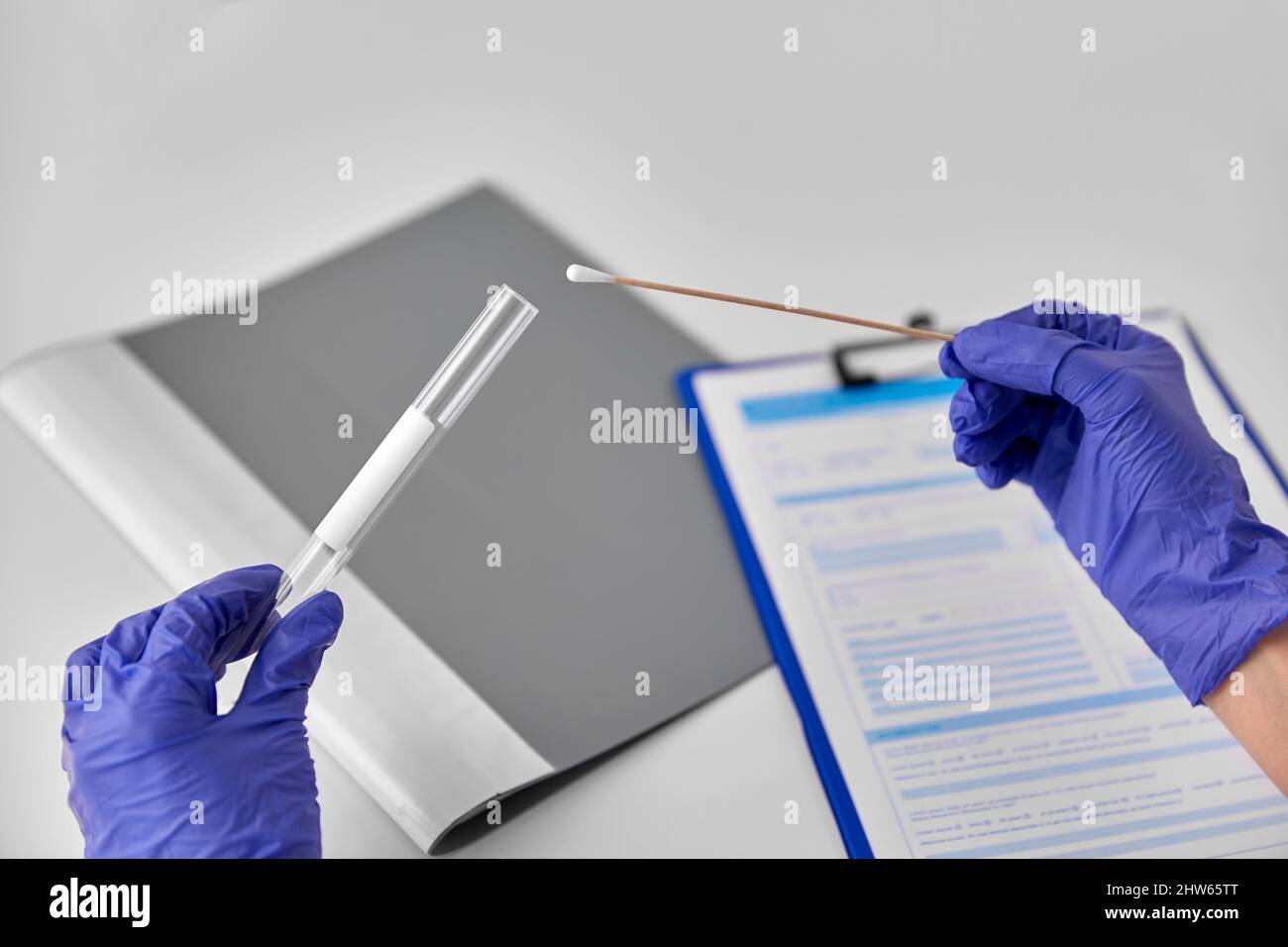 hands in gloves holding test tube and cotton swab Stock Photo - Alamy