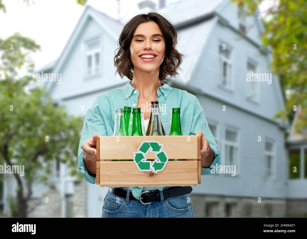 smiling young woman sorting glass waste outdoors Stock Photo - Alamy