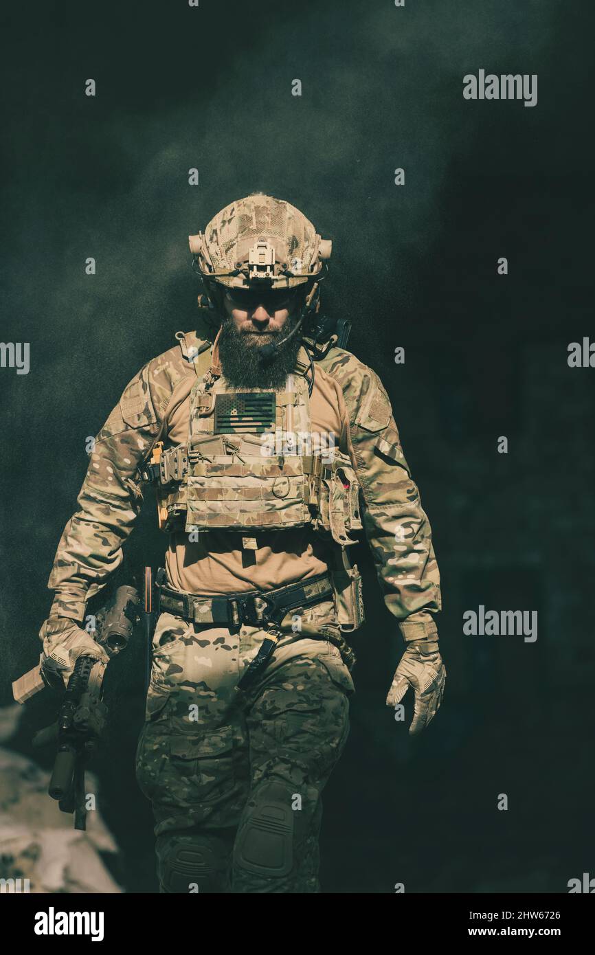 A bearded soldier in a special forces uniform walks through an ...