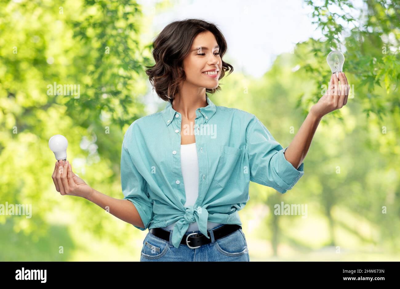 smiling woman comparing different light bulbs Stock Photo - Alamy