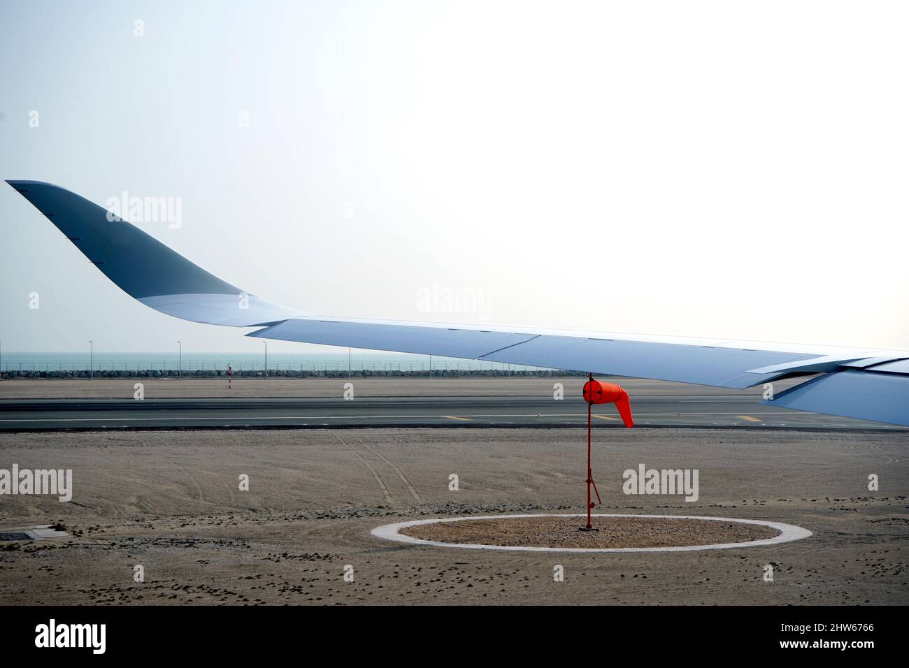 Wing and windscock view from passenger's window Stock Photo - Alamy