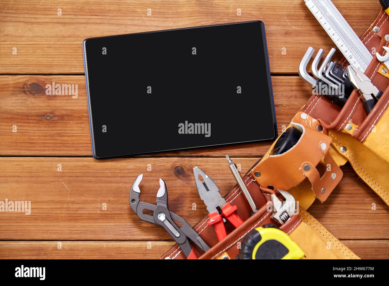 tablet computer and tool belt on wooden boards Stock Photo - Alamy