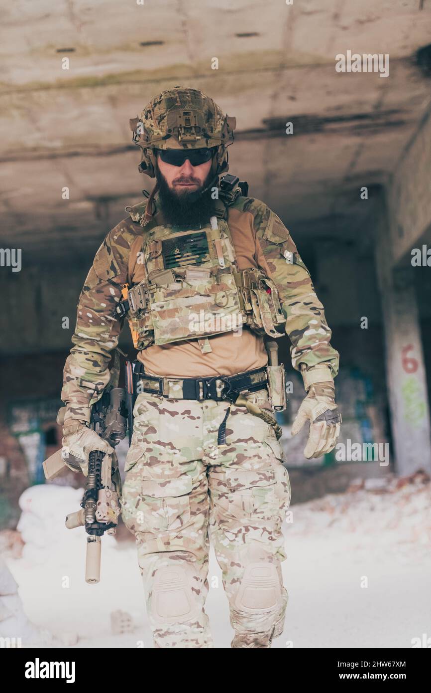 A bearded soldier in a special forces uniform walks through an ...