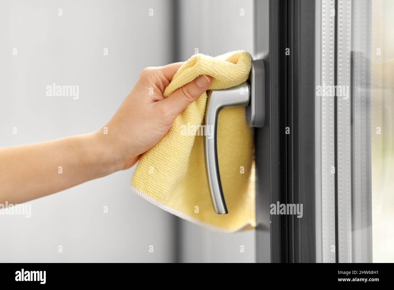hand cleaning window handle with microfiber rag Stock Photo - Alamy